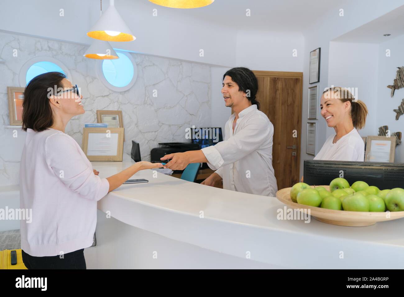 Resort hotel reception and registration of guests. Man and woman ...