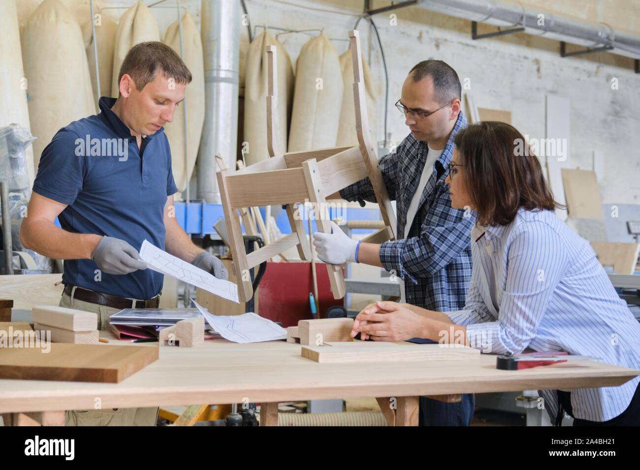 Industrial carpentry workshop, group of working people discussing new ...