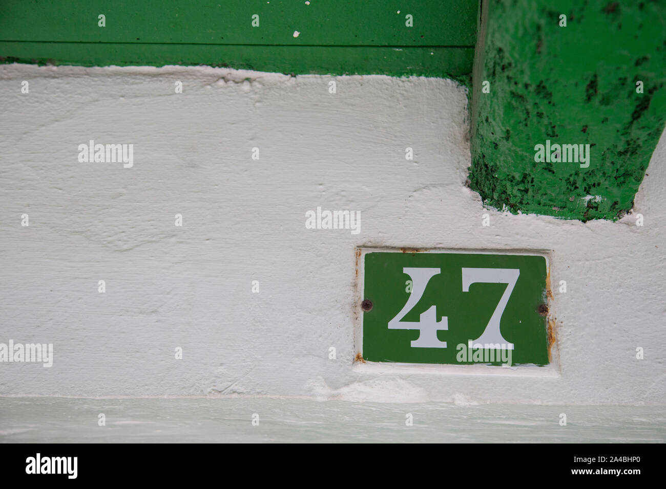Mediterranean style number plate with door number 47 in white on green ...
