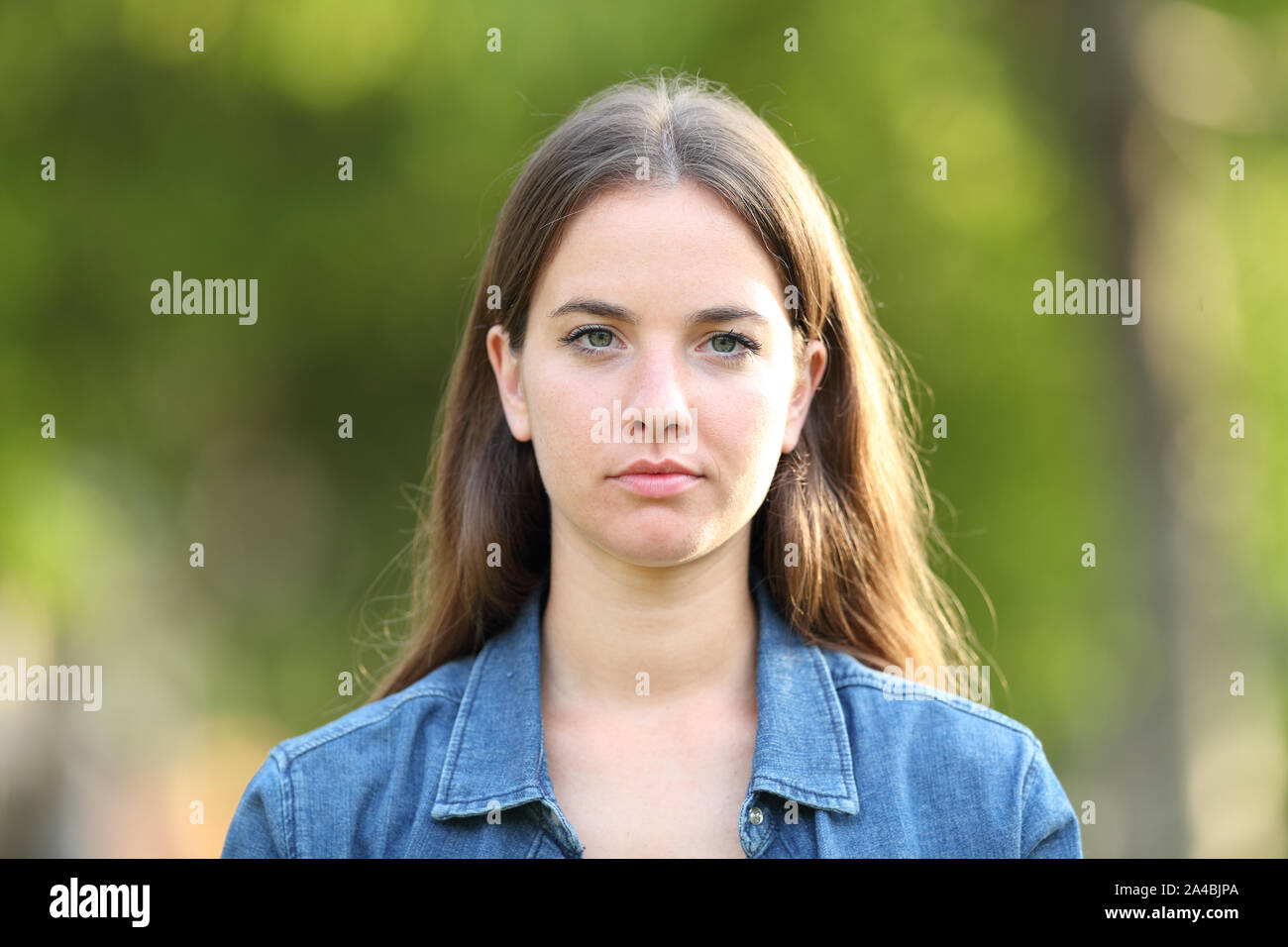 Front view portrait of a serious woman looking at camera in a park ...