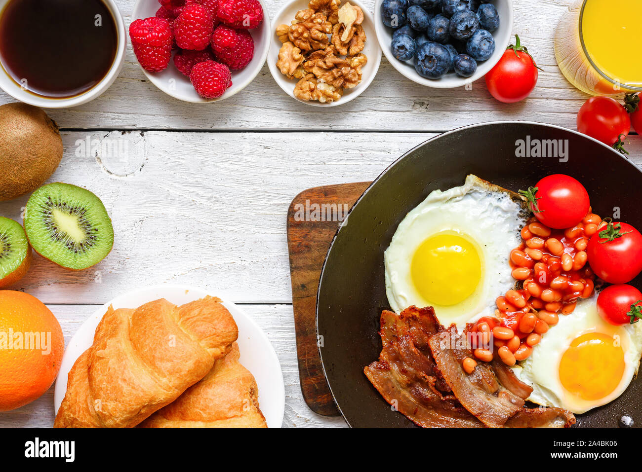 Breakfast buffet with fried eggs, bacon, beans, tomatoes, croissants ...
