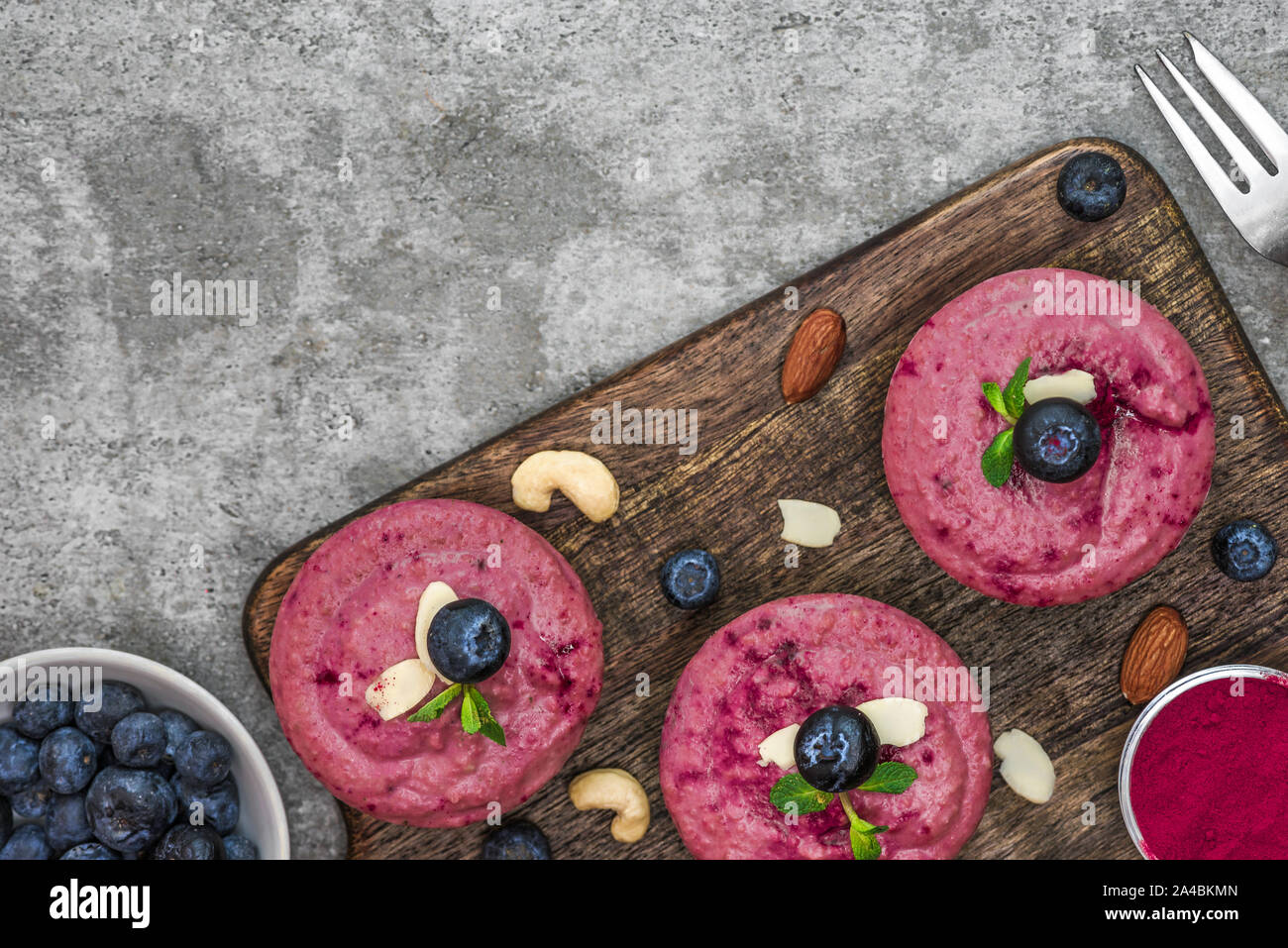 raw blueberry and acai vegan cakes with fresh berries, mint, nuts ...