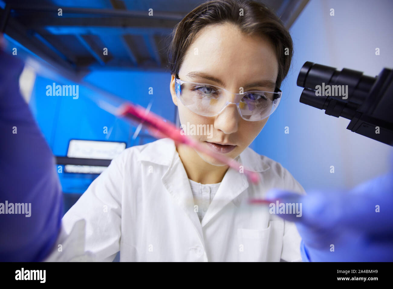 Fish eye view at young female scientist preparing test sample using ...
