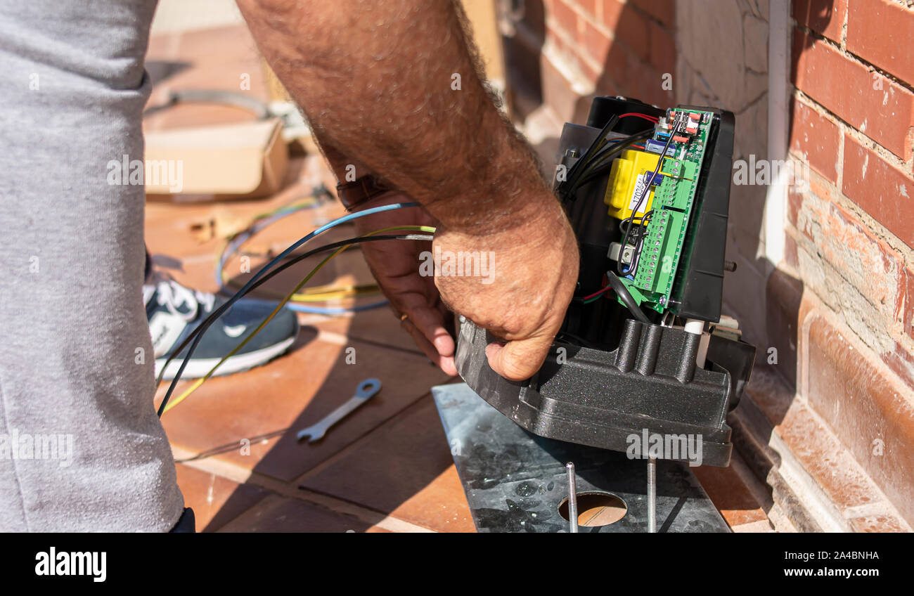 Hands of a man who are placing and installing an electric motor in a ...