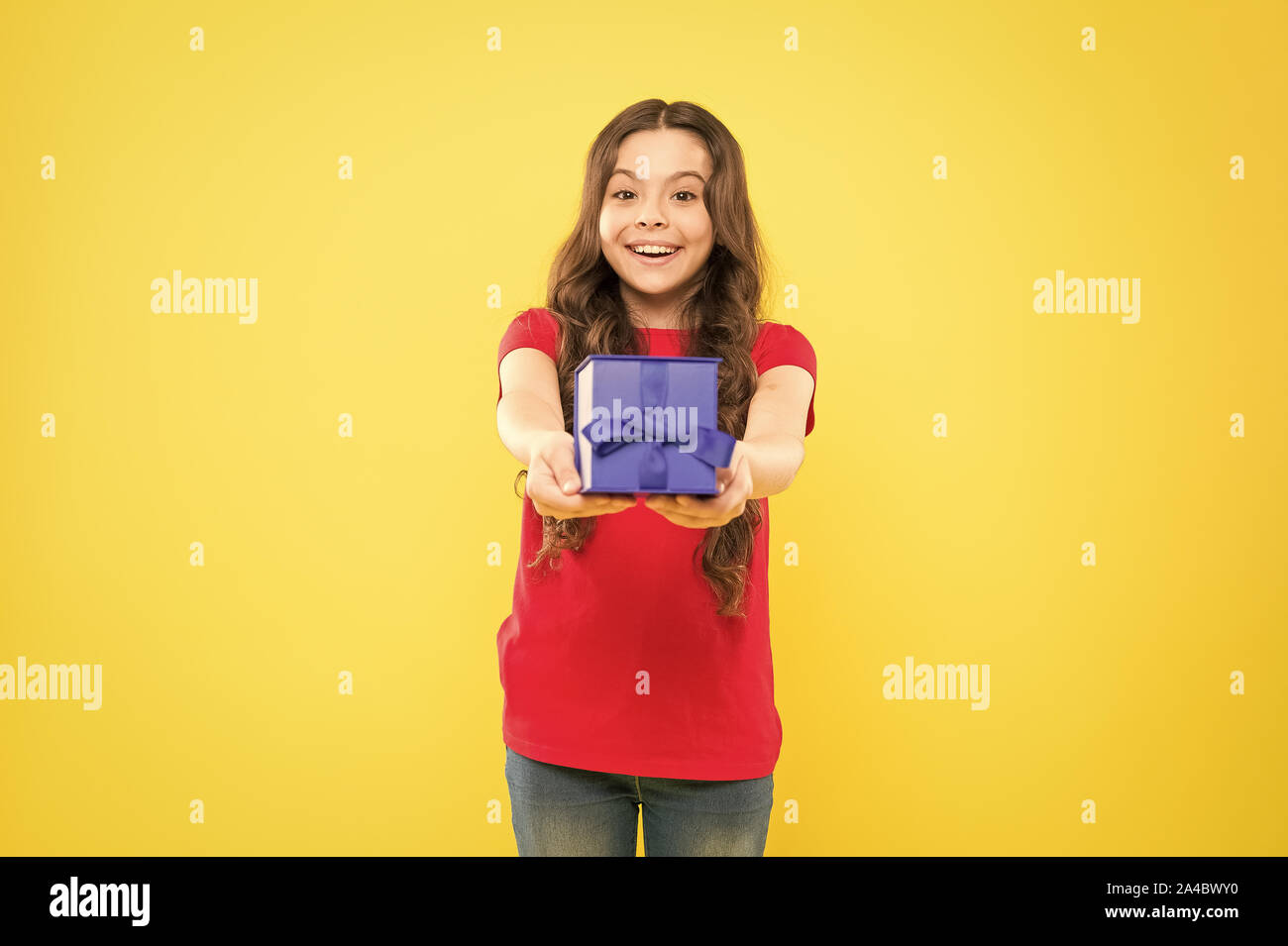Gift giving makes her happy. Adorable little girl giving blue present ...