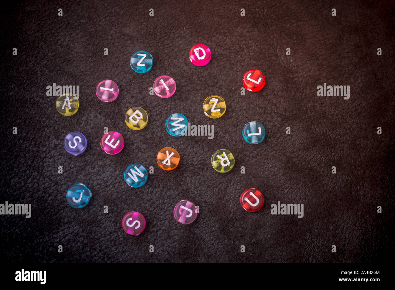 Multi color alphabet letter beads scattered randomly Stock Photo - Alamy
