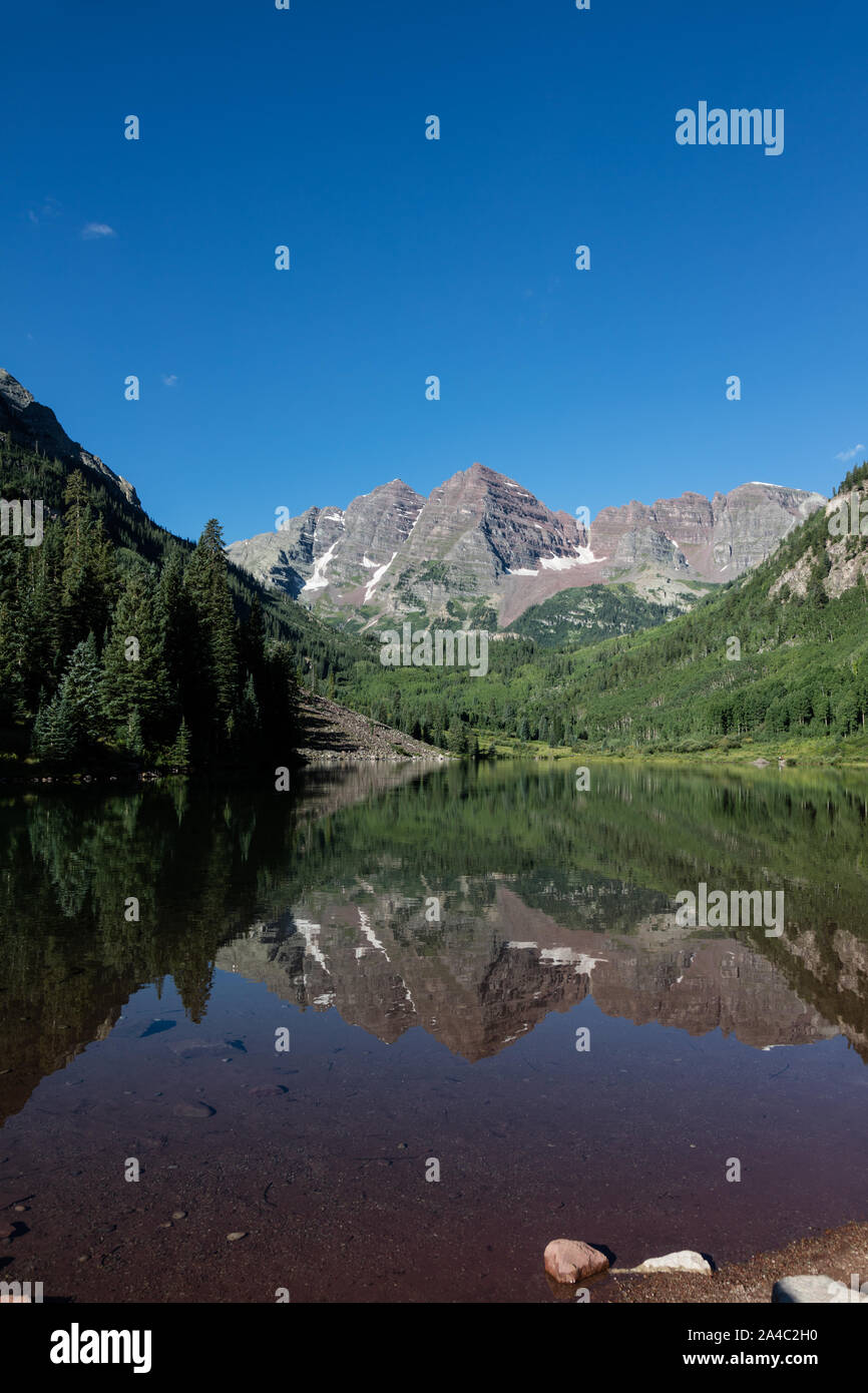 The Maroon Bells twin-peak formation reflects in Maroon Lake, just ...