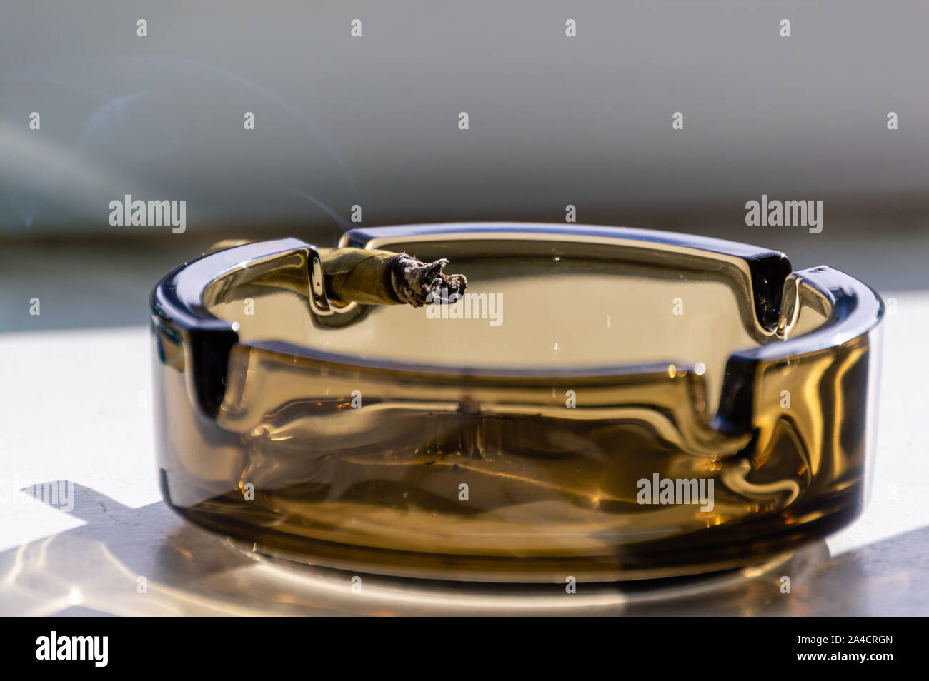 Burning cigar in ashtray hi-res stock photography and images - Alamy