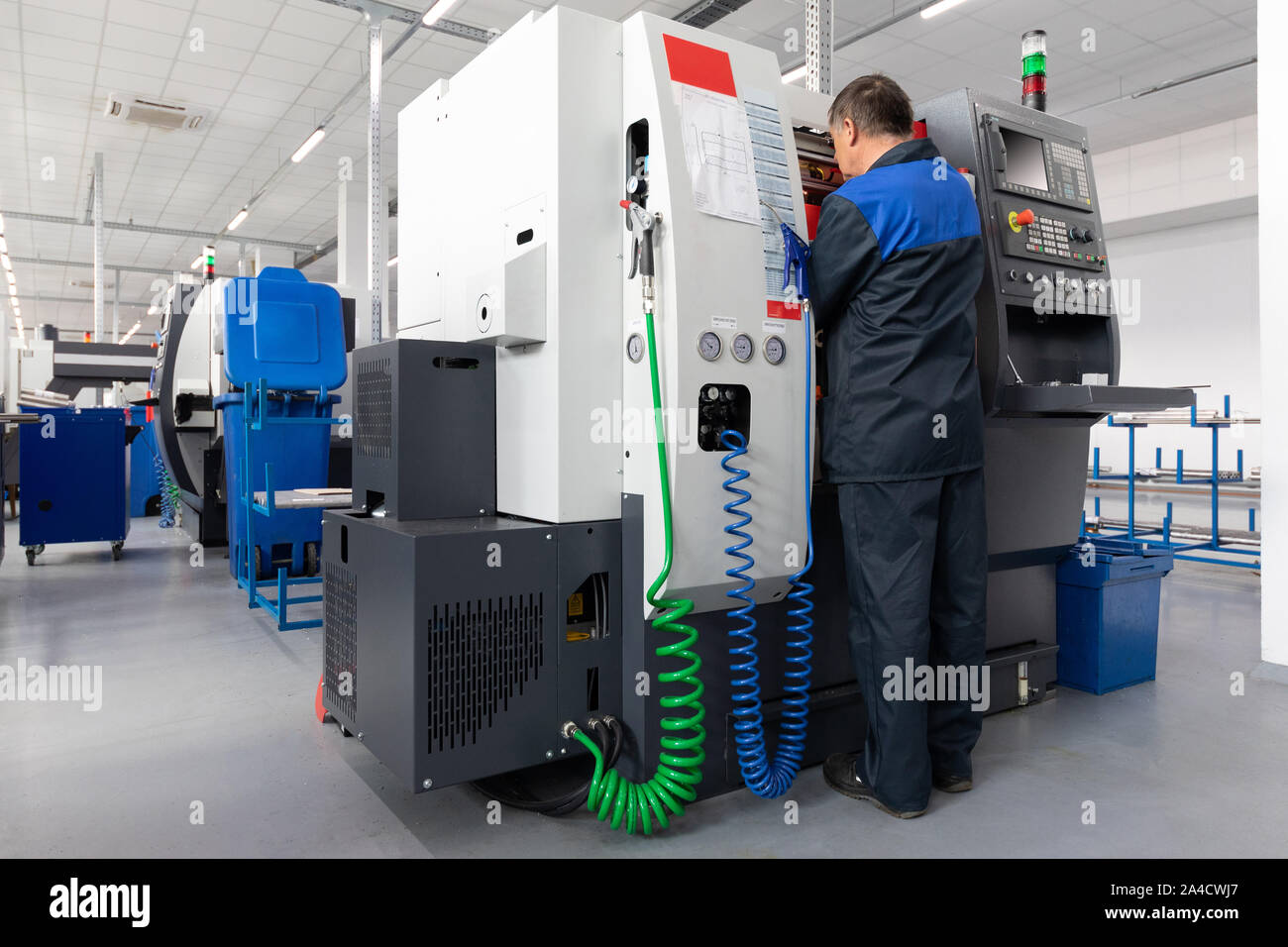 Engineer of metal processing equipment before panel with buttons Stock ...