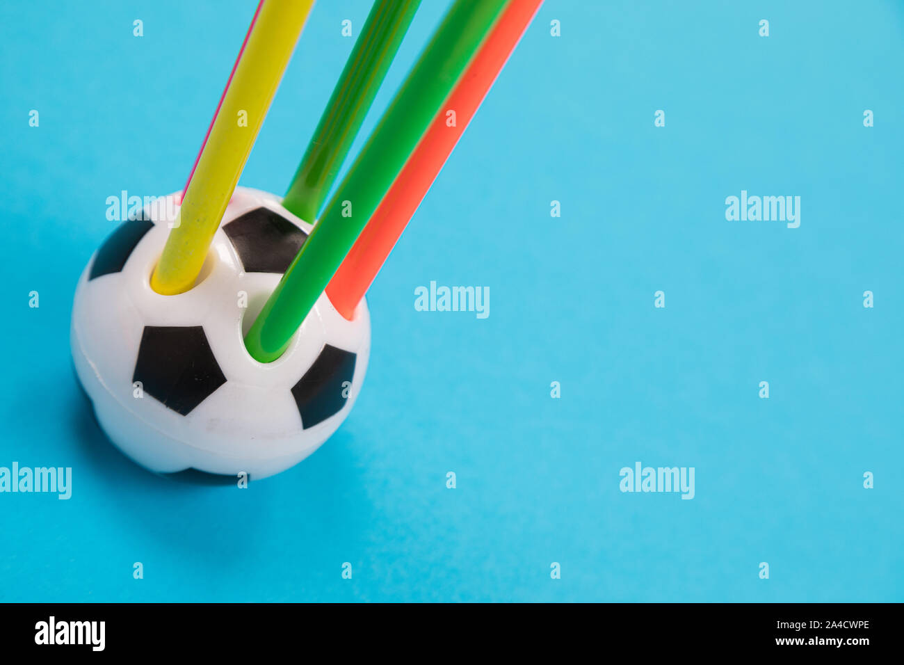 A round soccer ball shape pencil cup with five colorful pencils in it ...