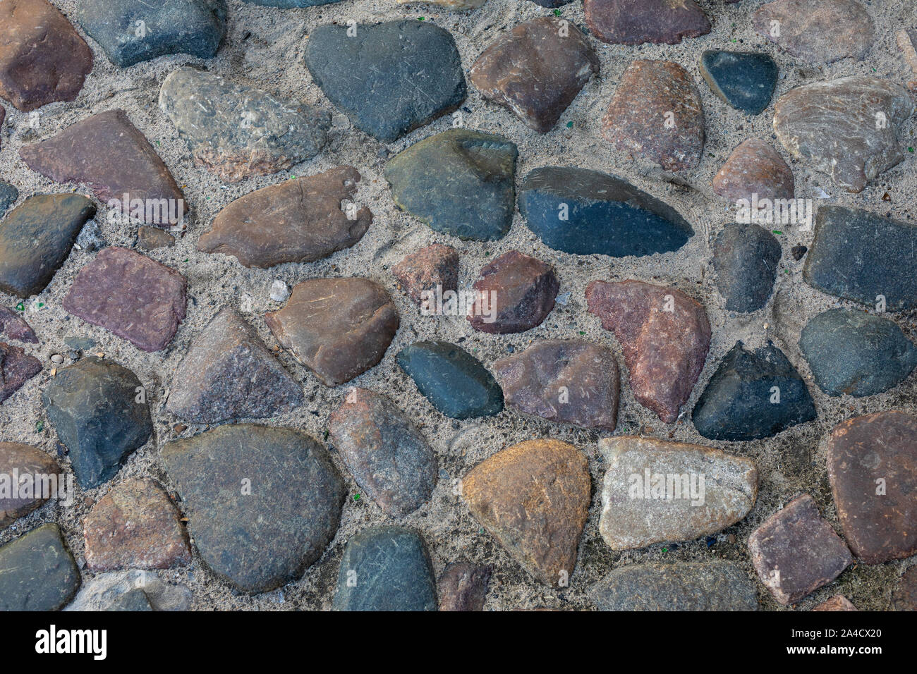 Abstract background of cobblestone pavement close-up. Top view on stone ...