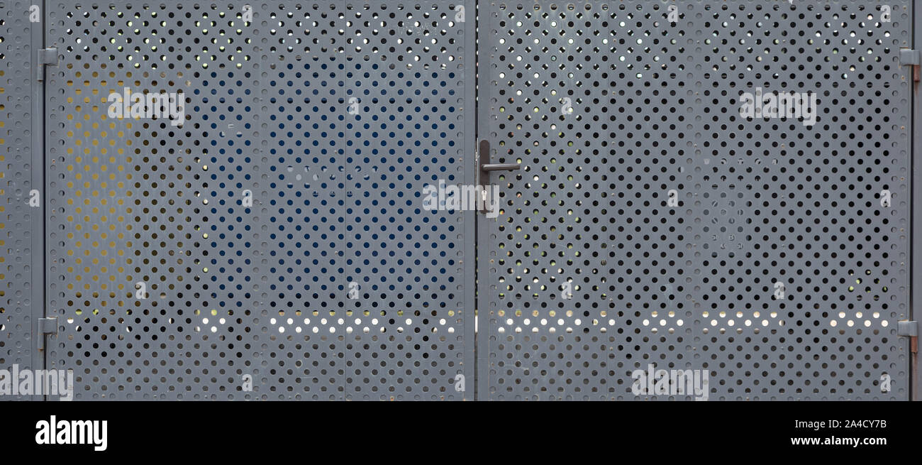 Panorama of metal gates with round openings Stock Photo - Alamy