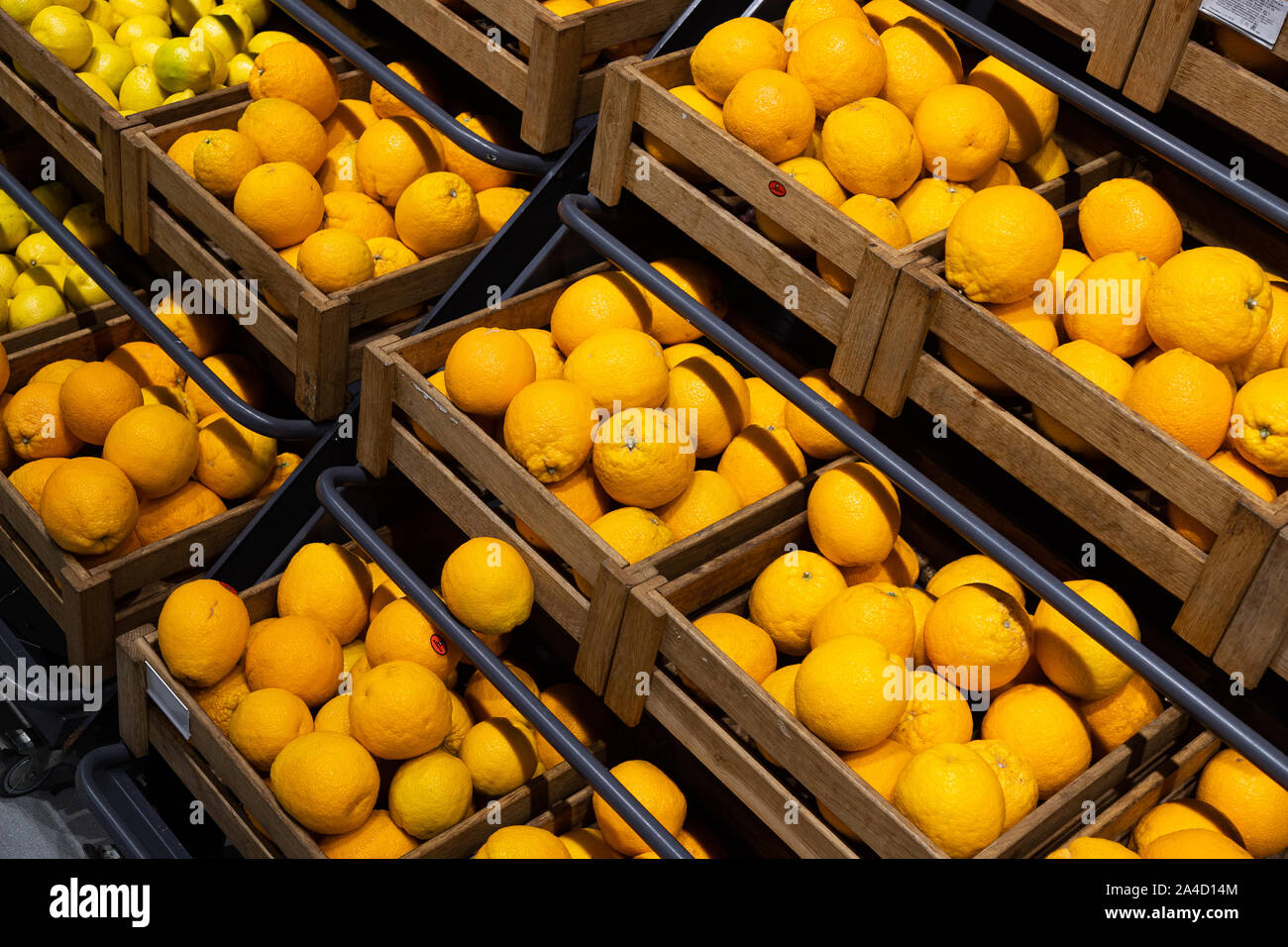Diagonal view of wooden lug boxes with ripe lemons on counter in ...