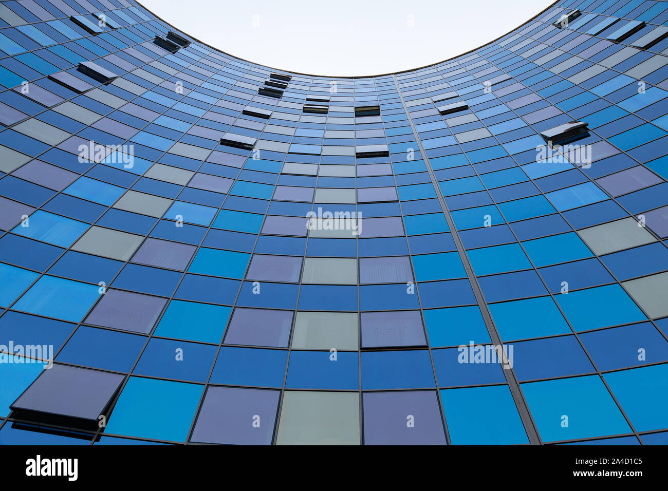 Ground view of blue glass surface of semicircle building front wall ...