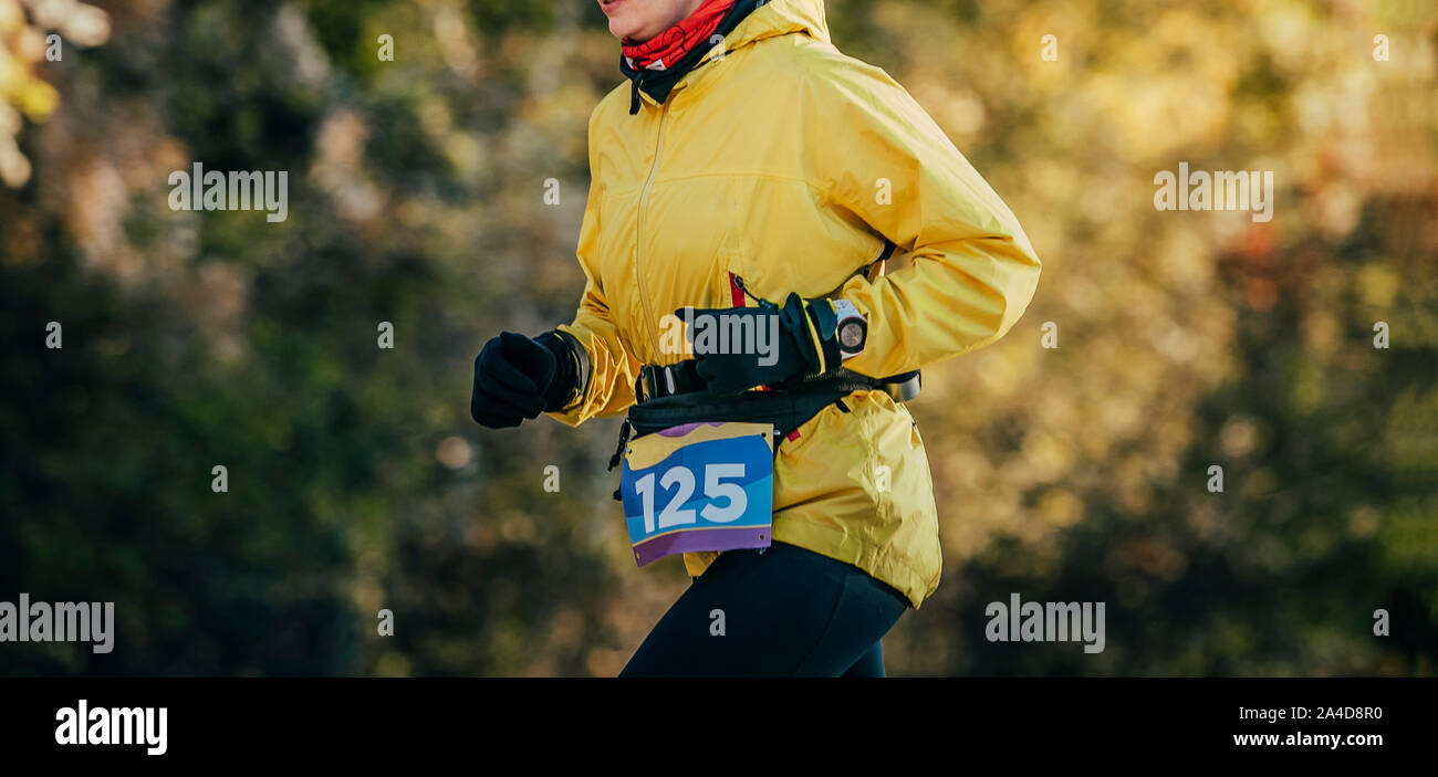 woman runner in yellow jacket run fall marathon Stock Photo - Alamy
