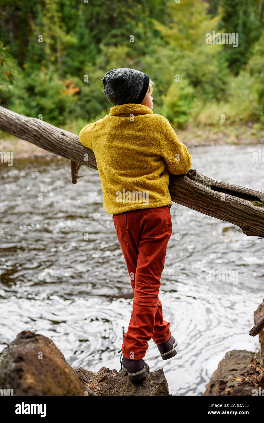 Boy standing on a rock by a river, United States Stock Photo - Alamy