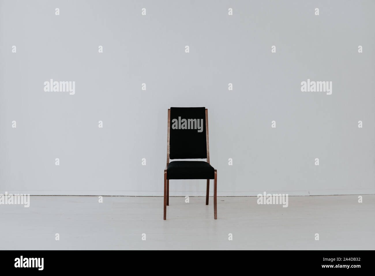 black chair stands alone in the white room Stock Photo - Alamy