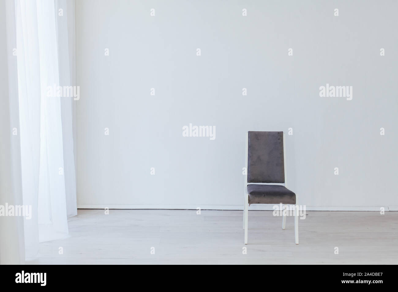 gray chair stands alone in the white room Stock Photo - Alamy