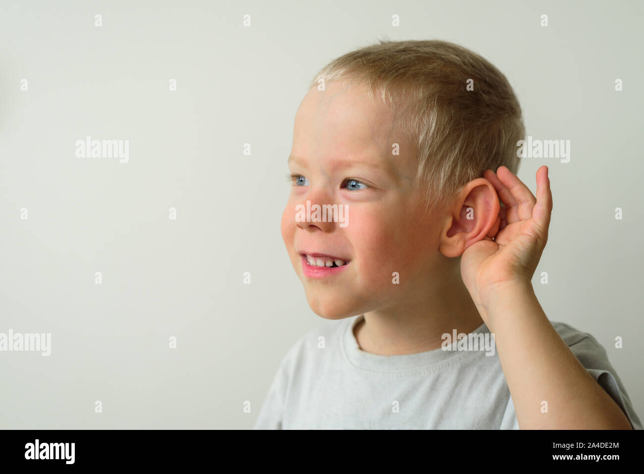 Little smiling boy with hearing gesture. Hearing children problems. Ear ...