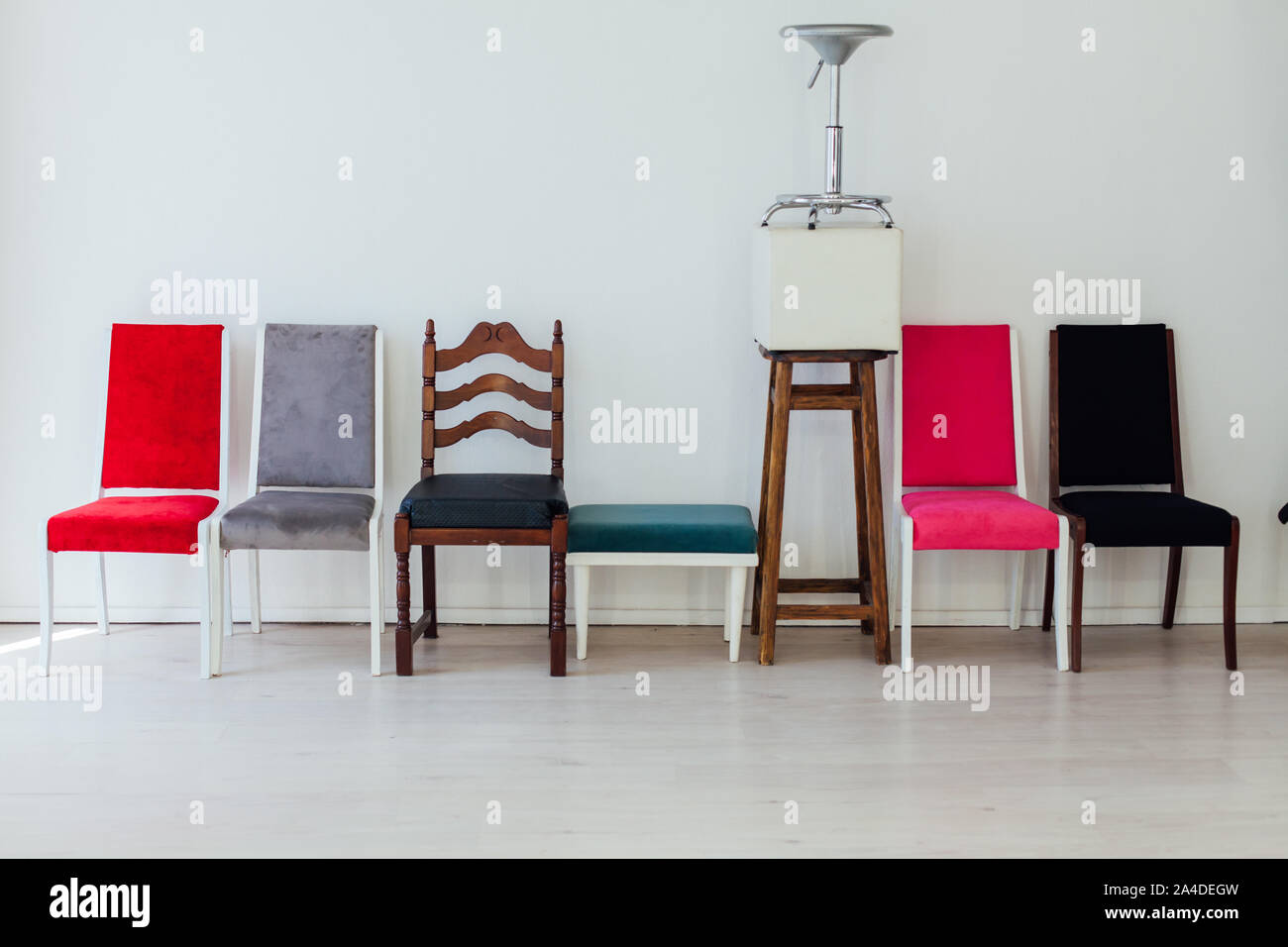 many different chairs stand in the white room Stock Photo - Alamy