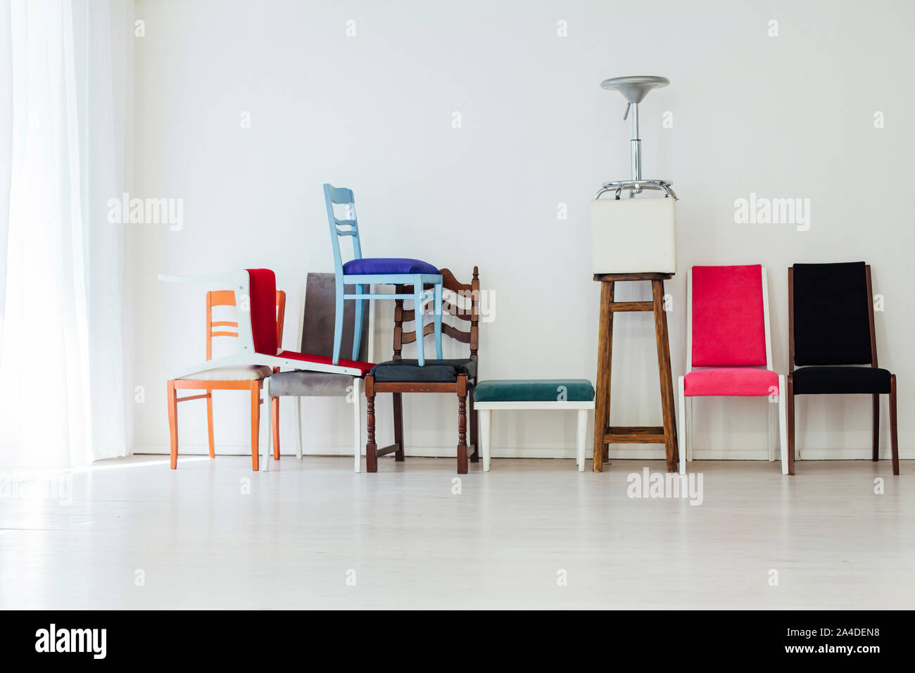 many different chairs stand in the white room Stock Photo - Alamy