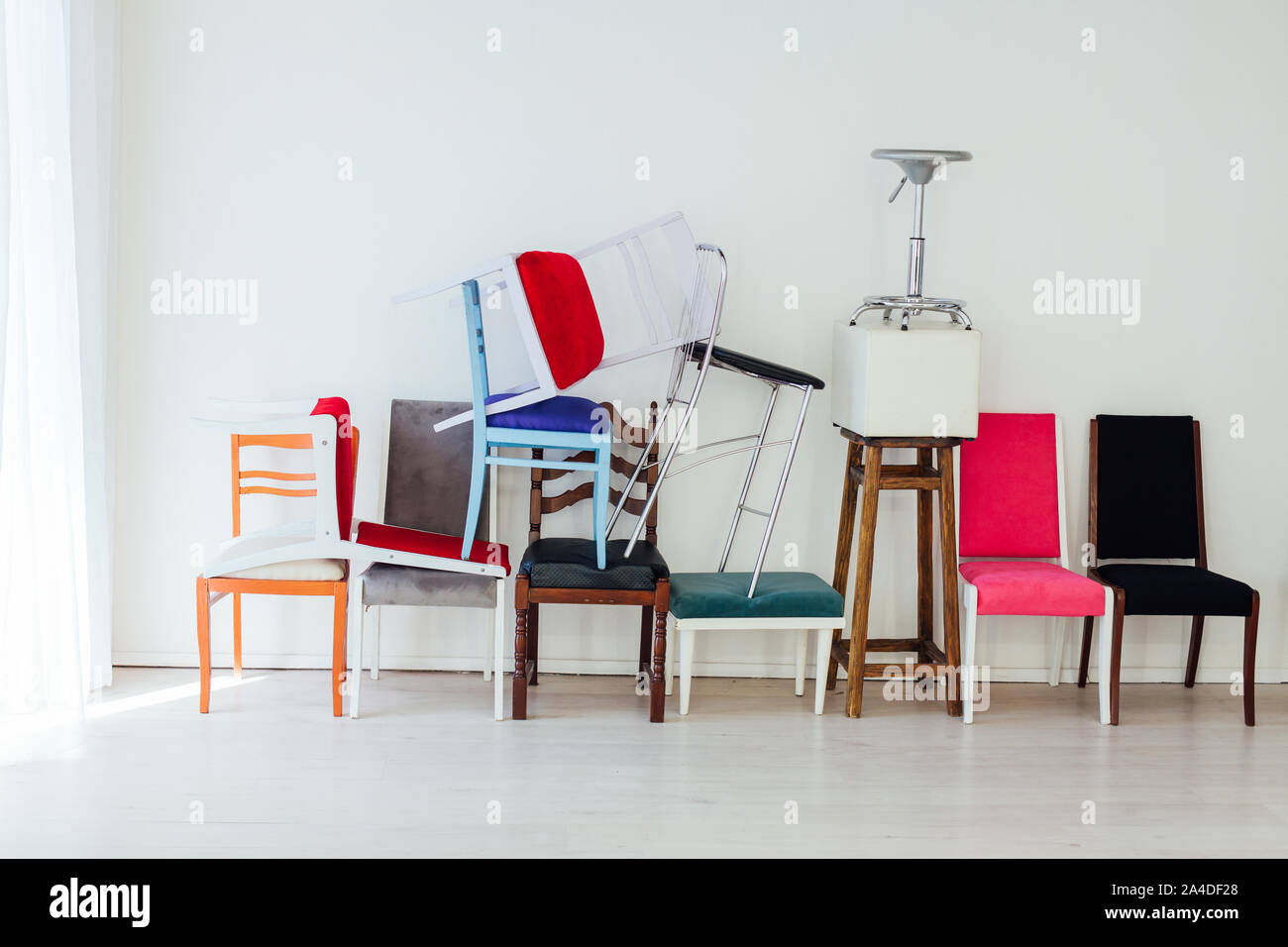 many different chairs stand in the white room Stock Photo - Alamy