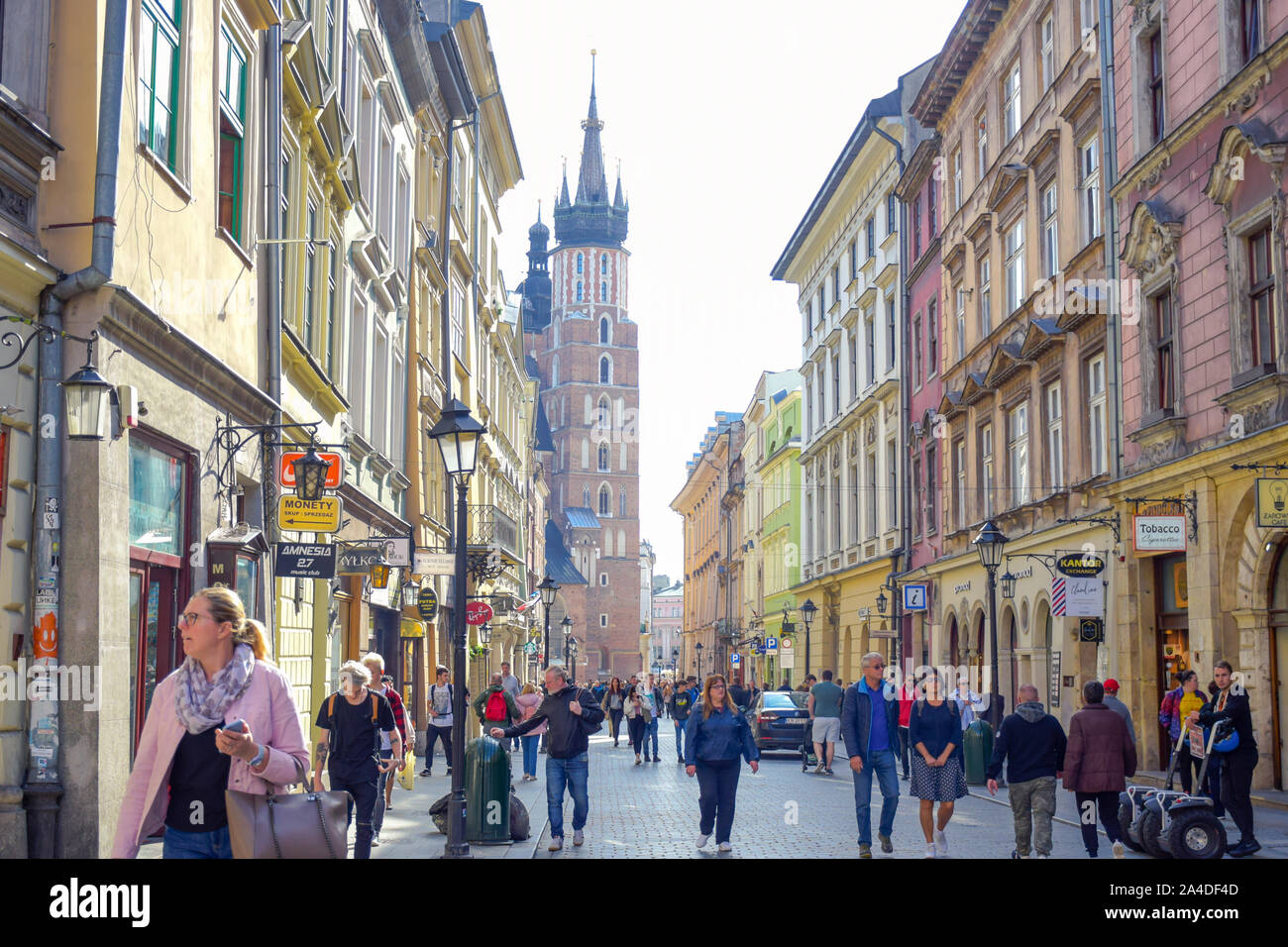 Tourists walking through Florianska street with St. Mary's Basilica ...