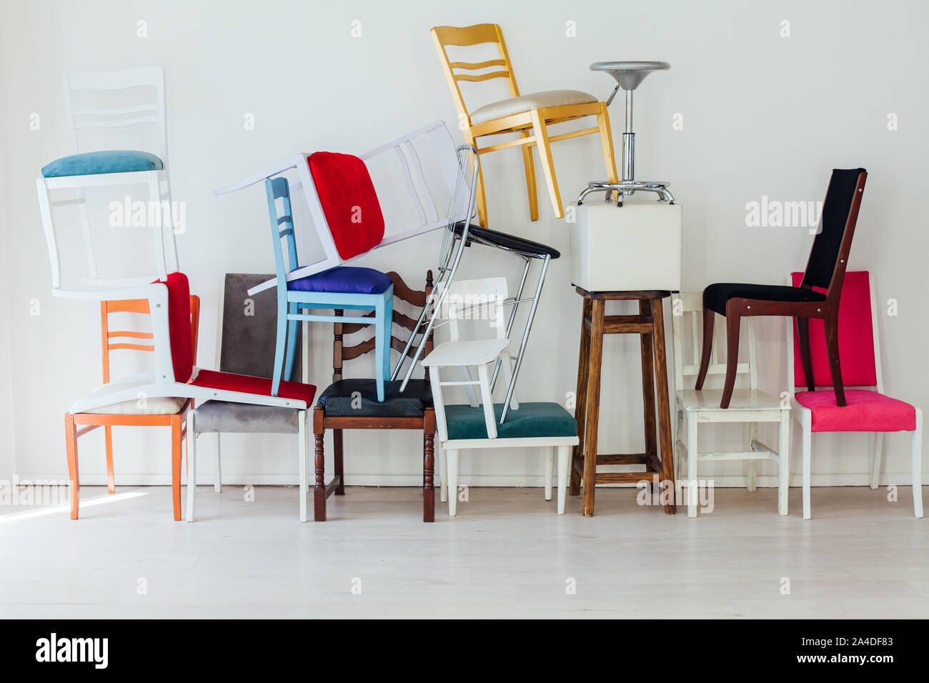 many different chairs stand in the white room Stock Photo - Alamy