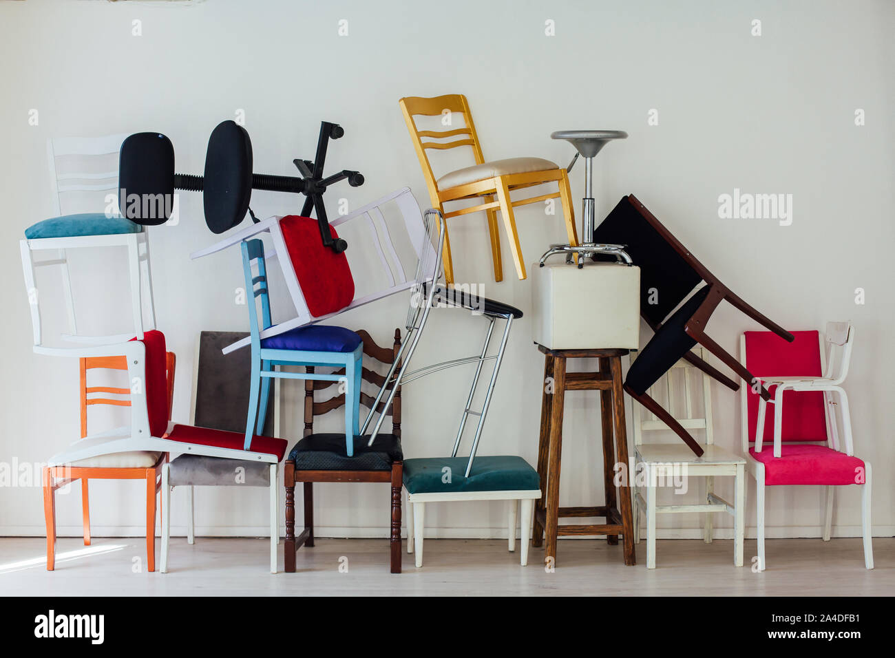 many different chairs stand in the white room Stock Photo - Alamy