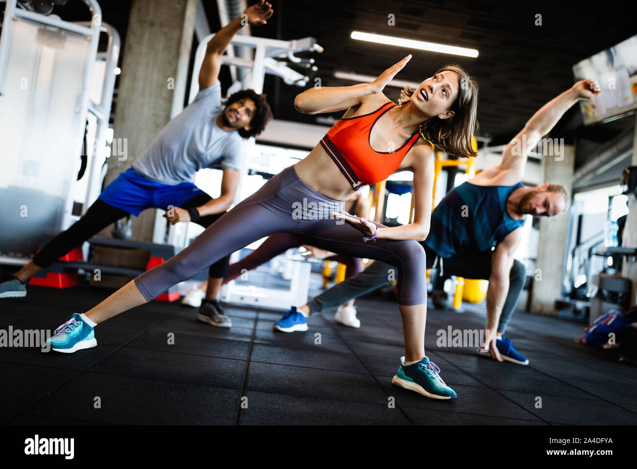 Healthy young people doing exercises at fitness studio Stock Photo - Alamy