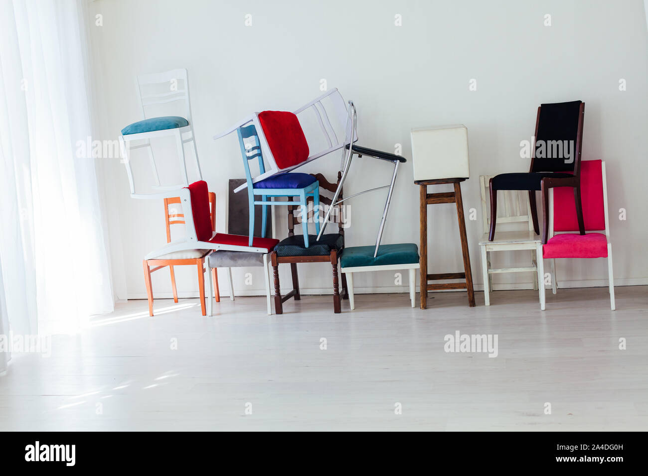 many different chairs stand in the white room Stock Photo - Alamy
