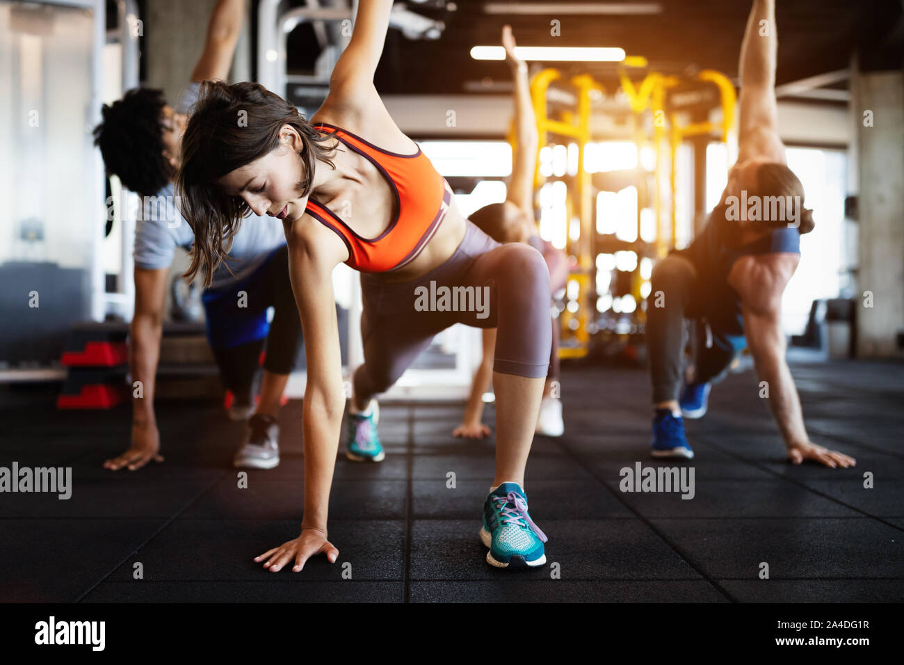 Group of young people doing exercises in gym Stock Photo - Alamy