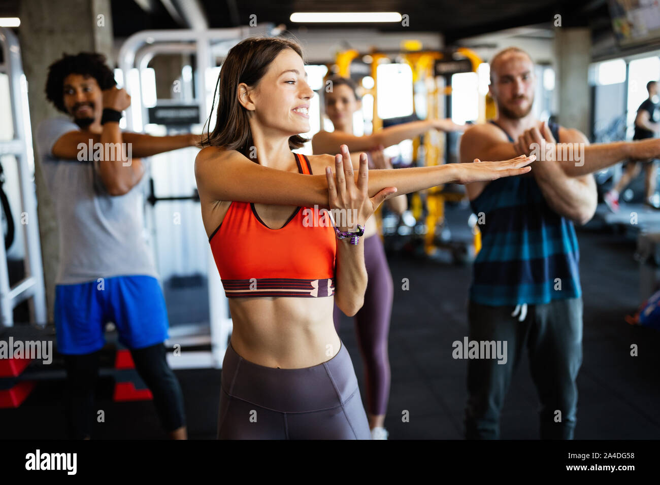 Healthy young people doing exercises at fitness studio Stock Photo - Alamy