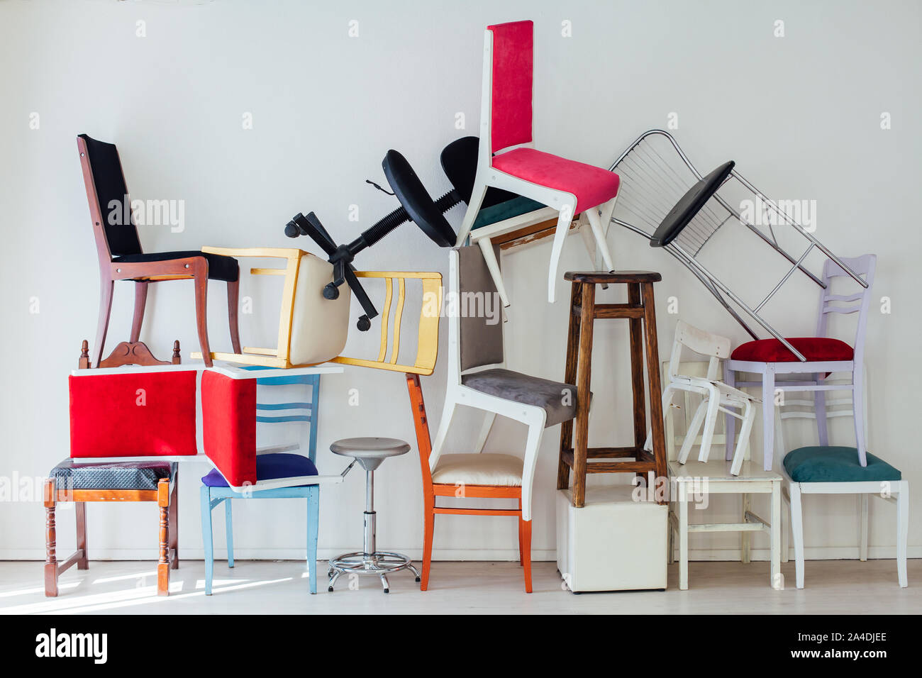 many multicolored chairs stand in the white room Stock Photo - Alamy
