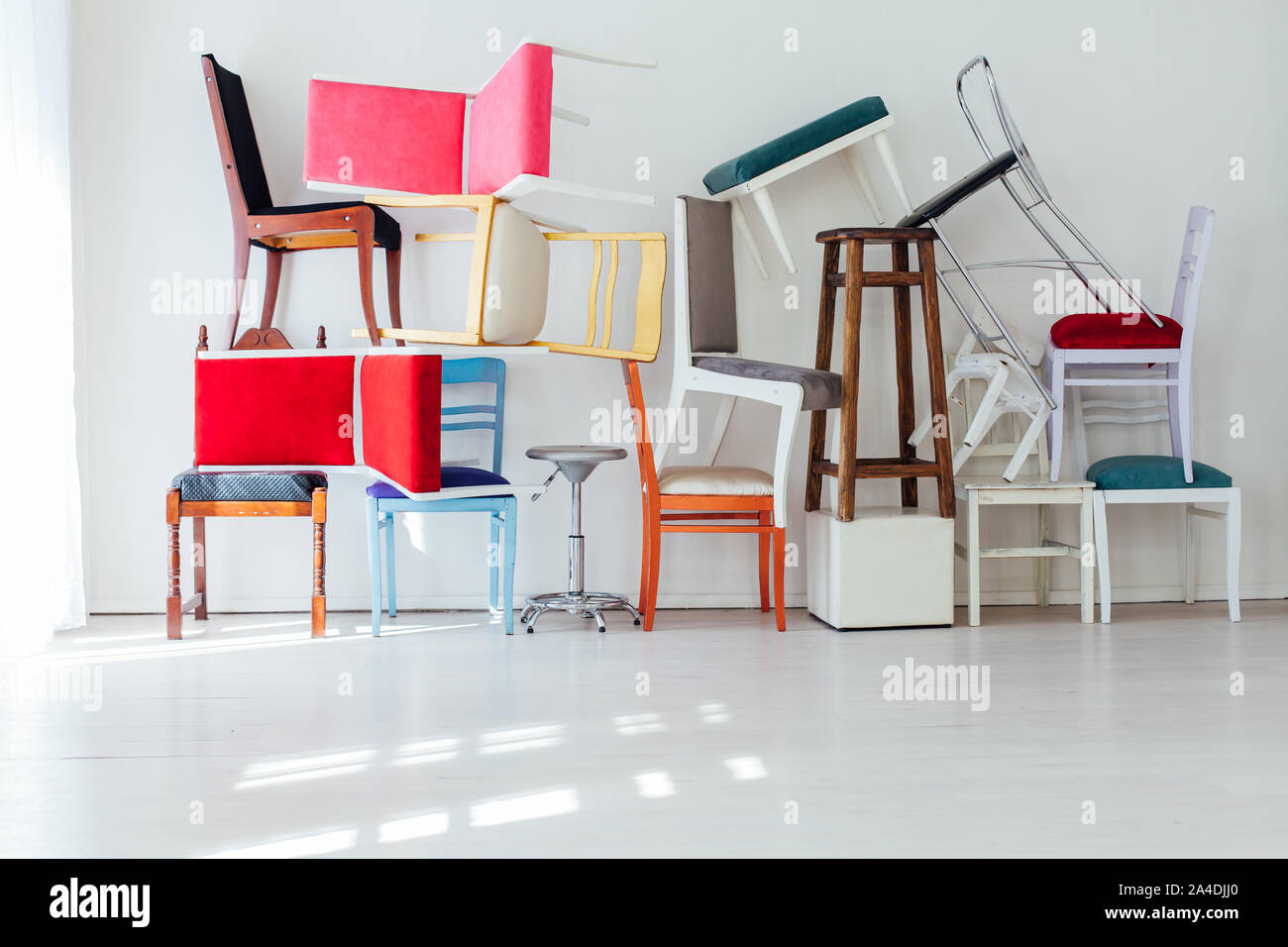 many multicolored chairs stand in the white room Stock Photo - Alamy