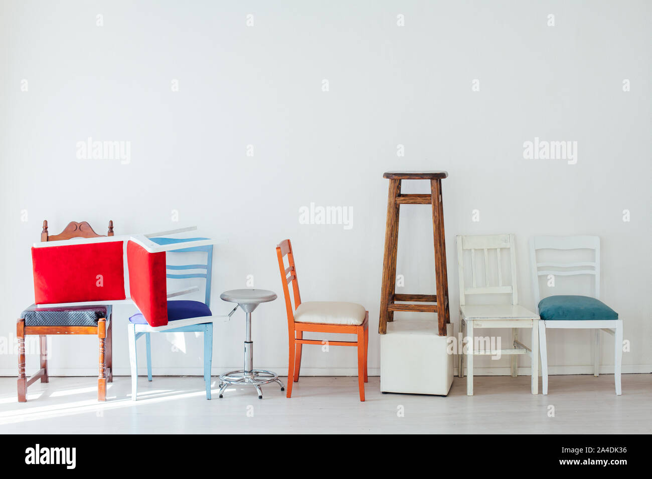 many different chairs stand in the white room Stock Photo - Alamy
