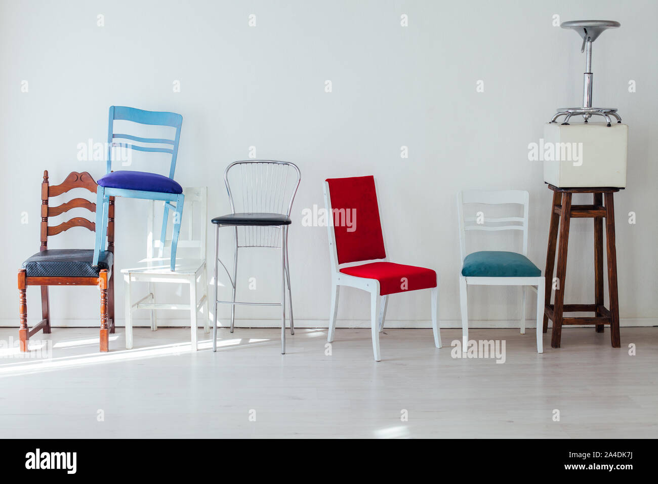 many different chairs stand in the white room Stock Photo - Alamy