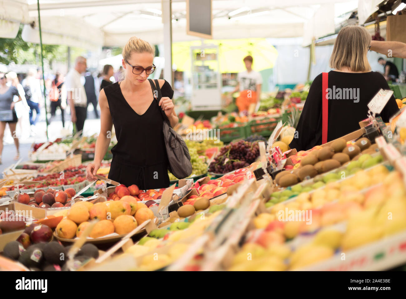Woman buying fruits and vegetables at local food market. Market stall ...