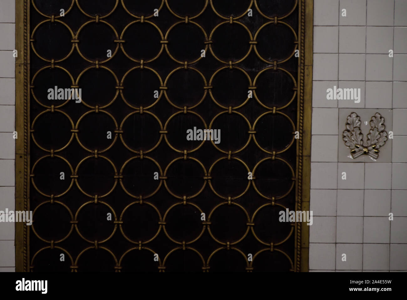 Old design element of the wall. Lattice with copper rings on the tiled ...