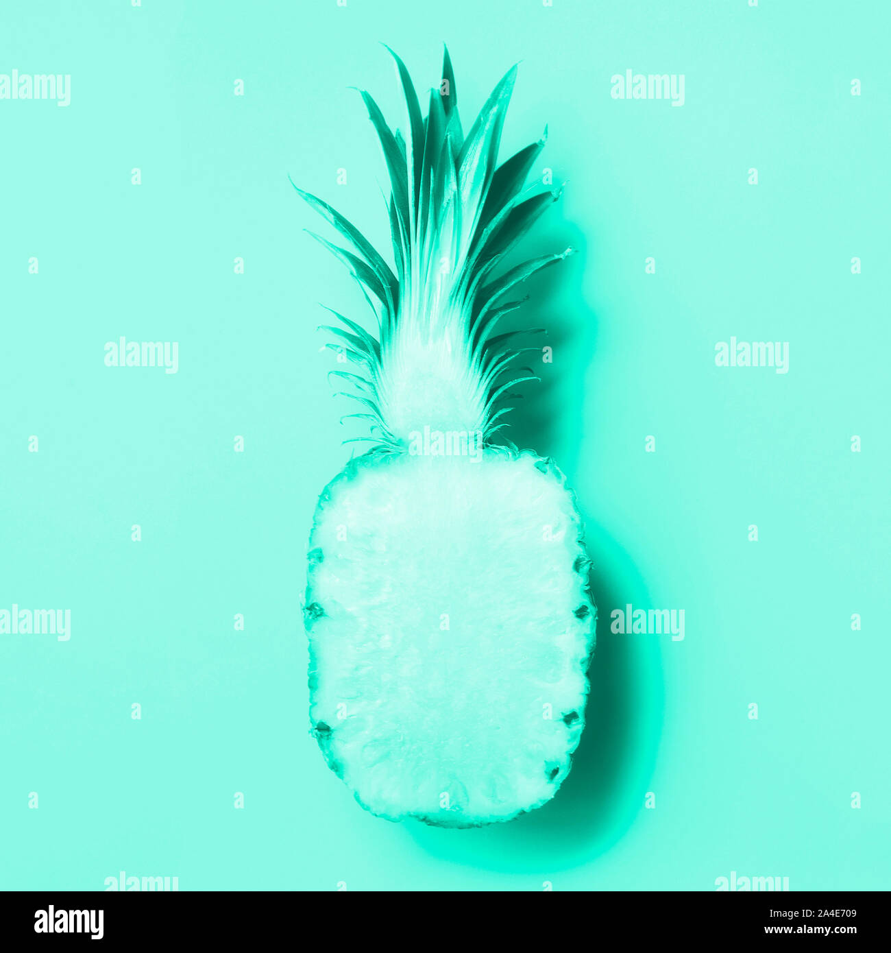 Half of sliced pineapple on mint color background. Trendy green and ...