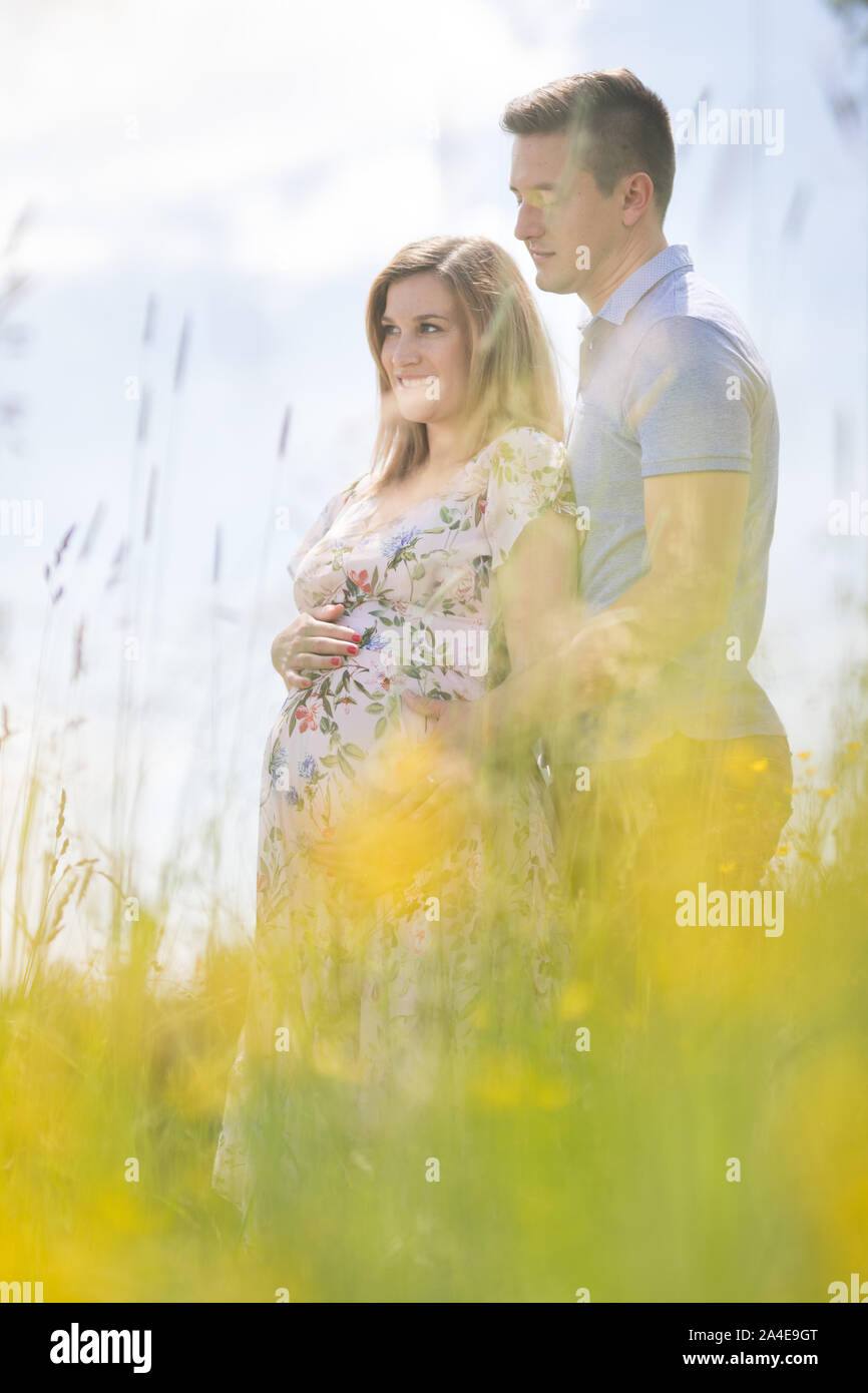 Young happy pregnant couple hugging in nature Stock Photo - Alamy