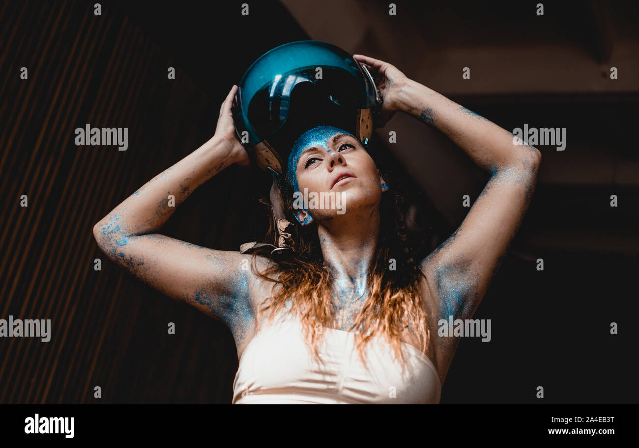 Woman motorcyclist put on crash helmet. Portrait of beautiful woman ...