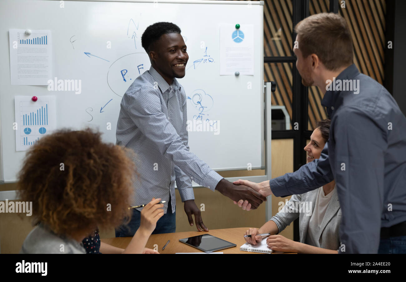 African and caucasian businessmen greeting each other shaking hands ...