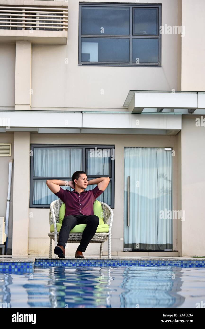 Adult Male Resting Sitting By Pool Stock Photo - Alamy