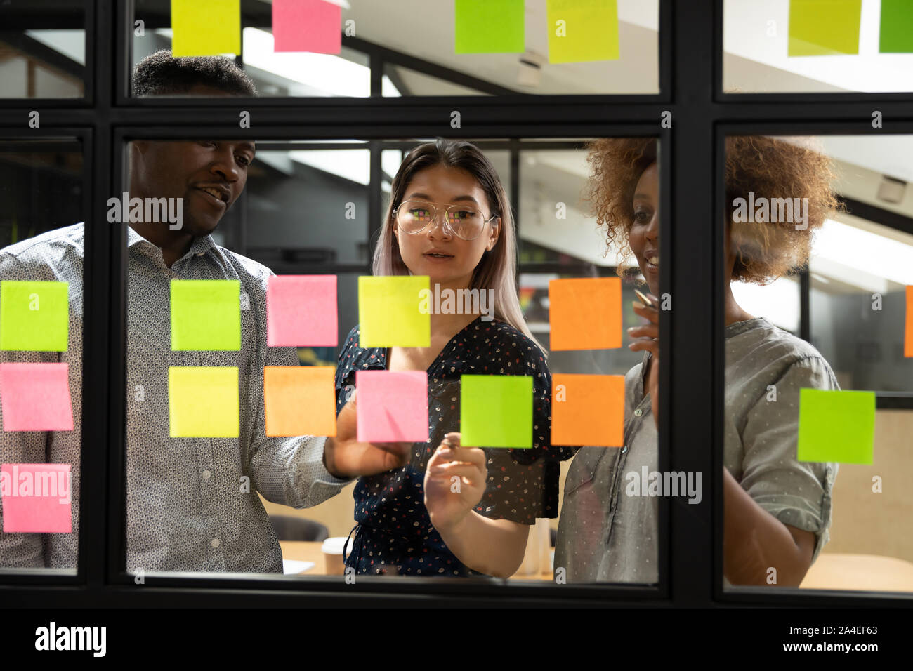 Diverse colleagues writing on sticky notes new project plan Stock Photo ...