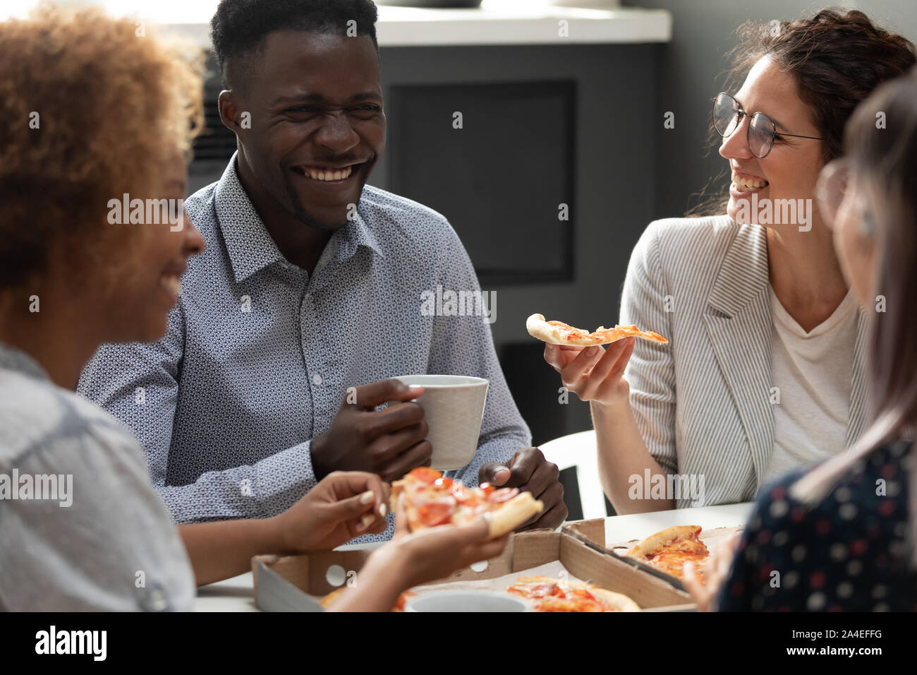 Team Of Multiracial Colleagues Eating Pizza Enjoy Lunch Break Stock