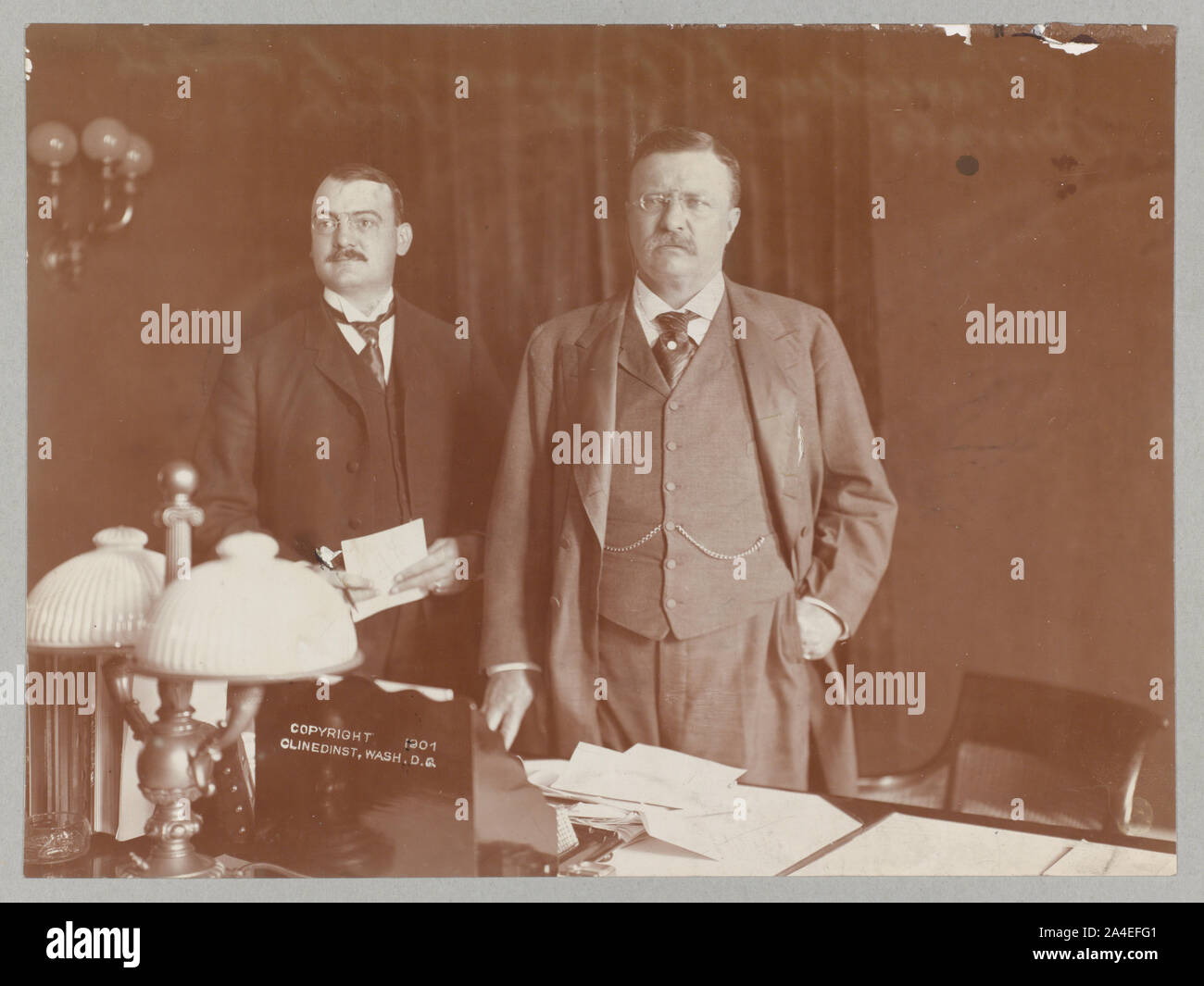 Theodore Roosevelt standing behind desk, facing slightly left, with ...