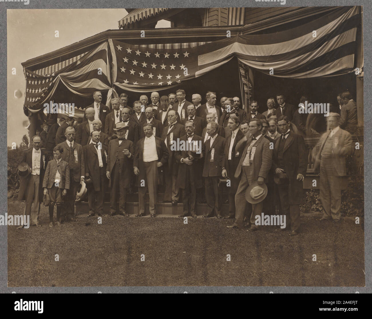 Theodore Roosevelt standing in center of a group of men outside a porch ...