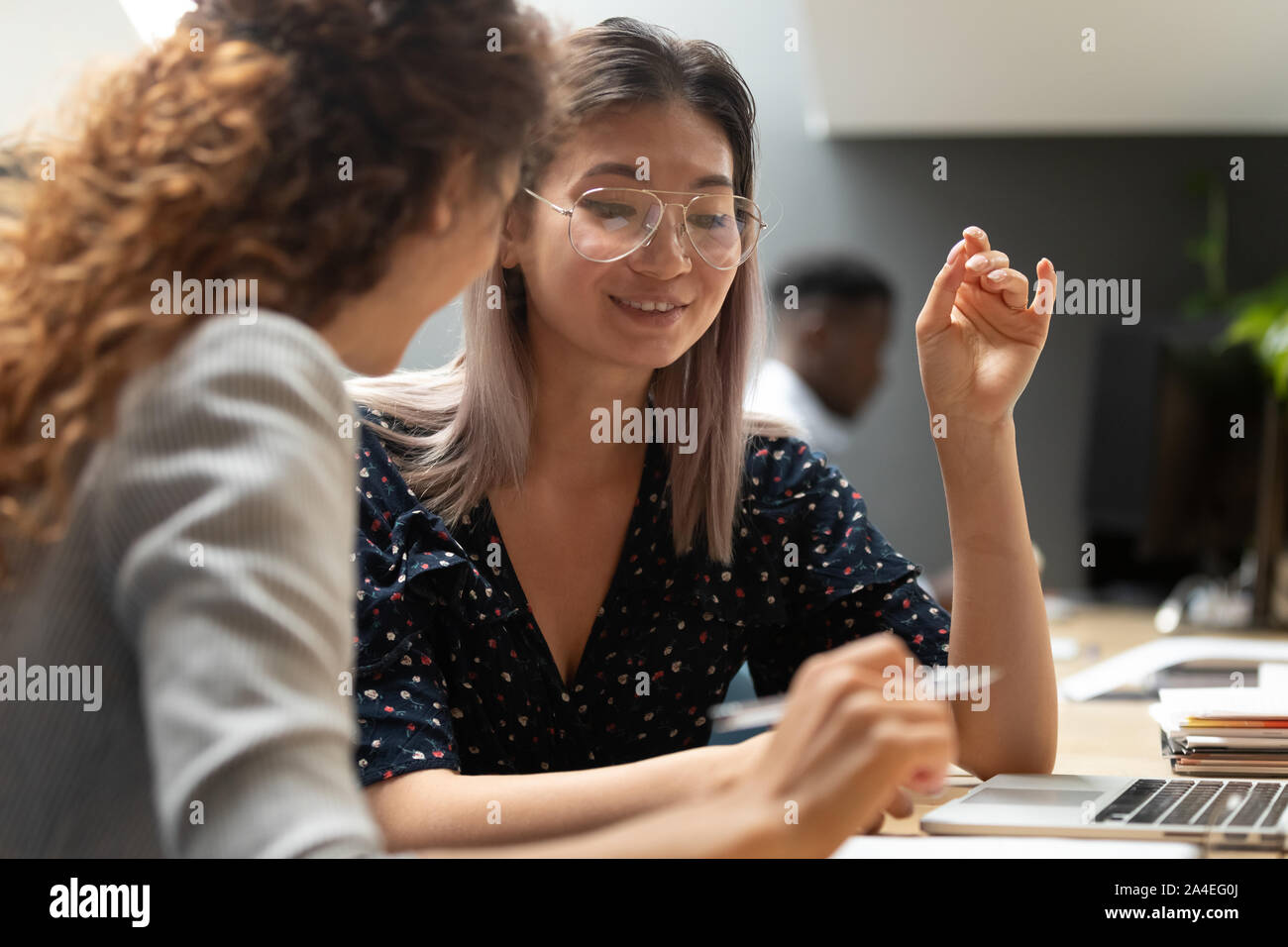 Multiethnic colleagues doing common task using laptop thinking on ...