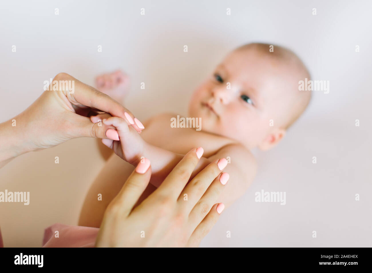 Mother hand massaging forearm of her baby on white background Stock ...